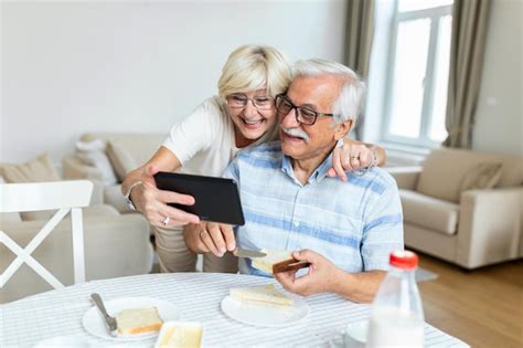 Premium Photo Senior Couple Smiling And Looking At The Same Tablet