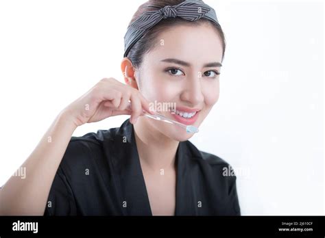 Beautiful Young Chinese Woman Using A Toothbrush To Clean And Whitening