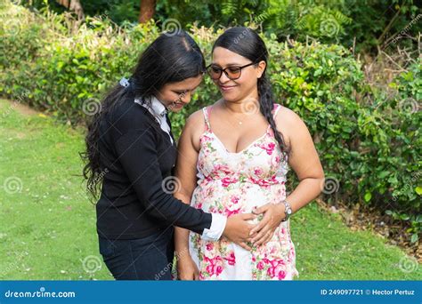 A Daughter Holds Her Mother`s Hands On Her Pregnant Belly Stock Image
