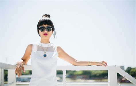 Stylish Asian Young Woman In White Clothes And Round Sunglasses By