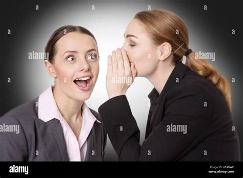 Close Up Shot Of Two Happy Pretty Business Women Sharing A Secret And