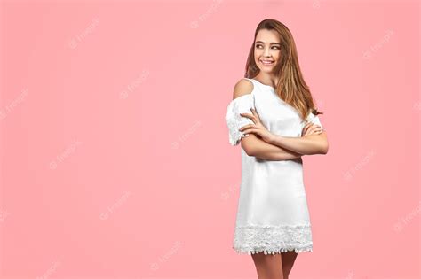 Hermosa Chica Con Vestido Blanco Y Posando Sobre Fondo Rosa Foto Premium