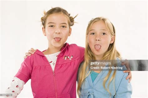 Two Girls Embracing Sticking Out Tongues Smiling Portrait Foto De Stock