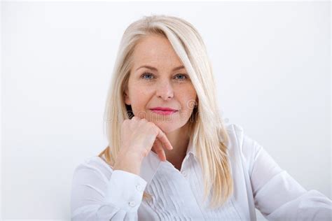 Lovely Middle Aged Blond Woman With A Beaming Smile Sitting At Office