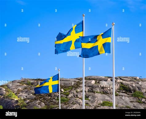 Three Swedish National Flags Waving On The Beach Of Hunnebostrand