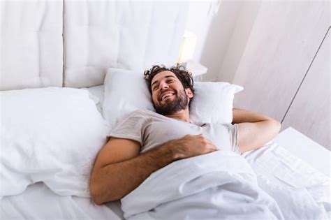 Premium Photo Young Man Sleeping Waking Up And Stretching In His Bed