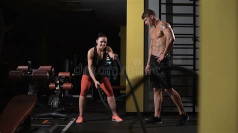 The Man Teaches His Girlfriend How To Do Elbow Plank In The Gym Stock