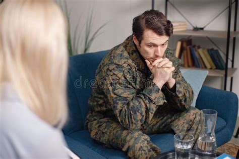 Soldier In Military Uniform Talking To Psychiatrist At Therapy Session
