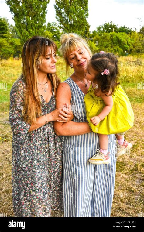 Grandmother Mother And Daughter Relaxing In Park Three Generations