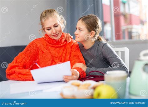 Mom Together With Her Daughter Write Letter On Paper At Home Stock