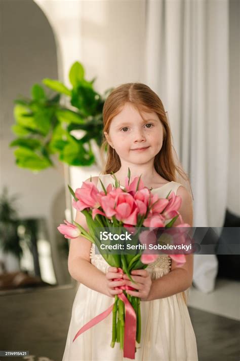 Beautiful Girl With Long Hair Standing And Holding A Big Bouquet Of