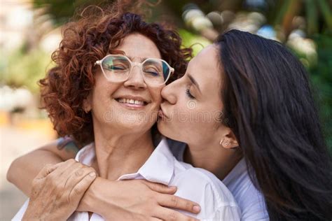 Two Women Mother And Daughter Hugging Each Other And Kissing At Park