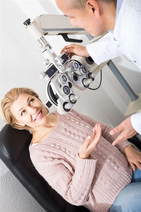 Mature Optician Examinating Eyesight With Aid Of Slit Lamp Stock Image