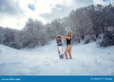 Attractive Woman Dressed In Swimsuit With Snowboard On The Slope Stock