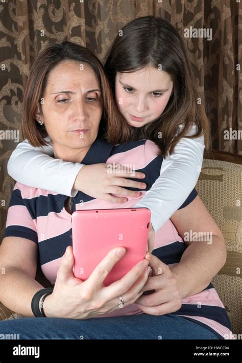 Mother And Daughter In Living Room Arguing And Holding Tablet Stock