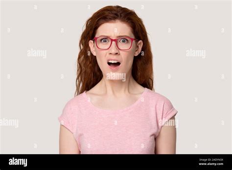Unpleasantly Surprised Red Haired Woman Looking At Camera Head Shot