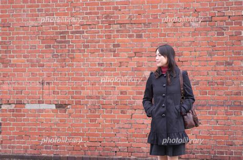 レンガの壁の前に立つ女性 写真素材 [ 1890382 ] フォトライブラリー Photolibrary