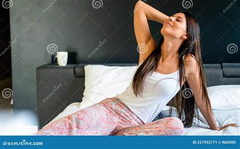 Happy Girl Waking Up Stretching Arms On The Bed In The Morning Stock