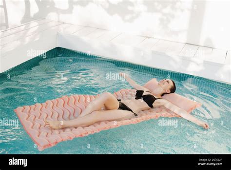 Jeune Femme Se Faire Bronzer Au Bord De La Piscine Banque De