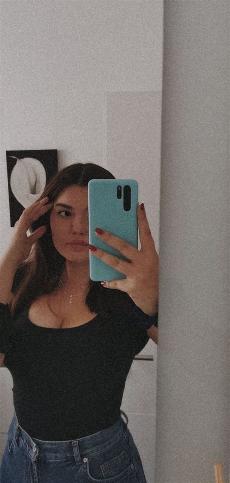 A Woman Taking A Selfie In The Mirror With Her Phone Up To Her Ear