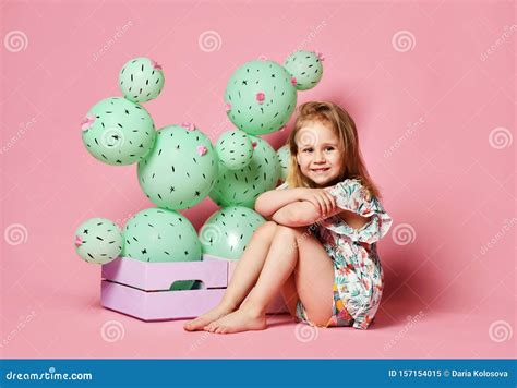 Jeune Fille De 4 Ans Tenant Une Balle De Cactus Dans Une Boîte En Bois