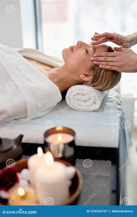 Young Blonde Woman Receiving Face And Head Massage In Spa Center Side