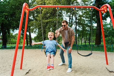 Photo Libre De Droit De Père Et Fils Samuser Sur Swing Au Terrain De