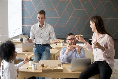 Friendly Diverse Team Talking And Laughing Eating Pizza Together Happy