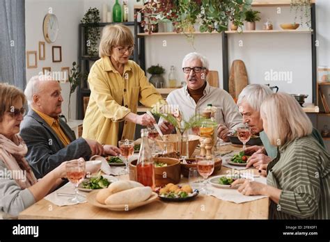 Group Of Senior People Sitting At Dining Table Having Dinner And