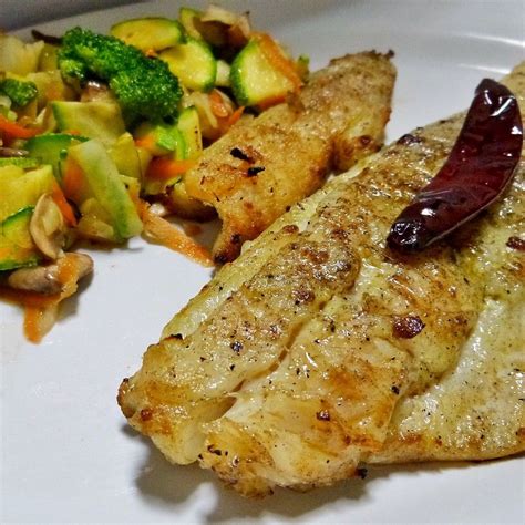 El Filete De Pescado A La Leña Acompañado De Una Guarnición De Verduras
