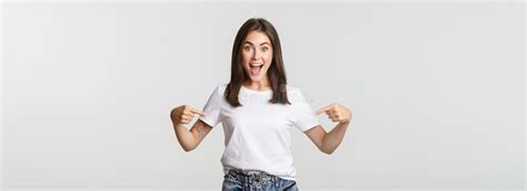 Excited Happy Brunette Girl Smiling Pointing Fingers At Logo Showing
