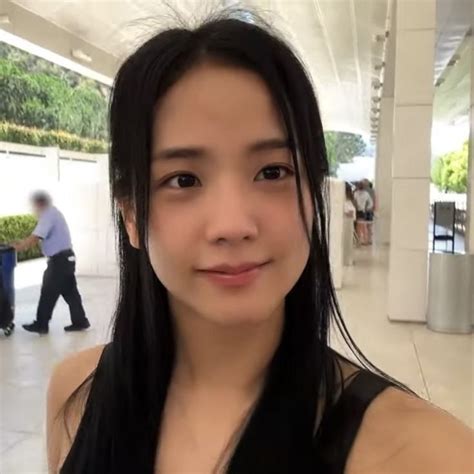 A Woman With Long Black Hair Standing In An Airport
