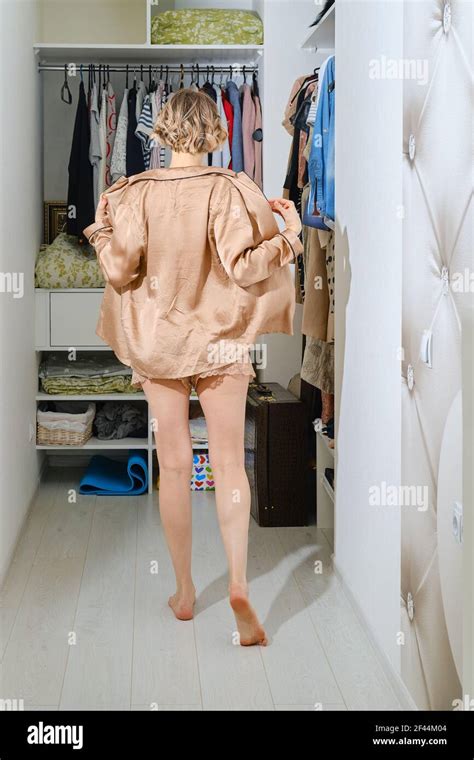 Vista Posterior De Una Mujer Que Va Al Vestidor Y Quitándose Su Pijama