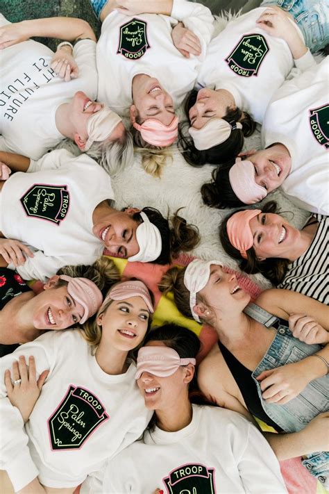 A Group Of People Laying On Top Of Each Other Wearing White Shirts And