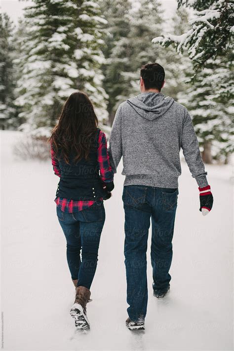 Fun Adventurous Couple Holding Hands Walking In Winter Landscape In