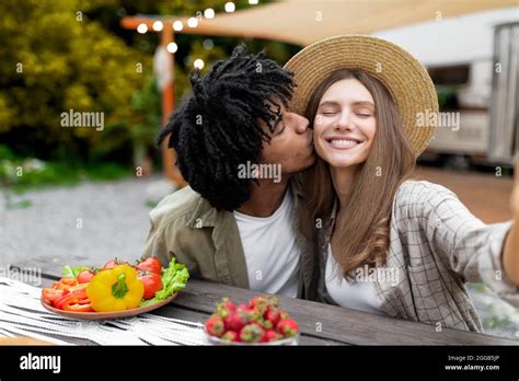 Loving Afro Guy Kissing His Caucasian Girlfriend While Making Selfie On