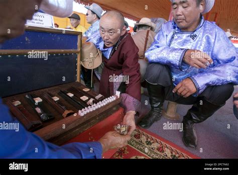 Mongolian Men Play A Game Of Ankle Bone Shooting Which Involves