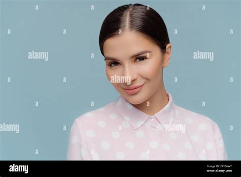 Headshot Of Pleasant Looking Dark Haired Female Has Pleased Facial