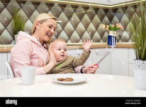 Maman Et Son Fils Chattent Au Téléphone Et Branle Leur Mains Photo