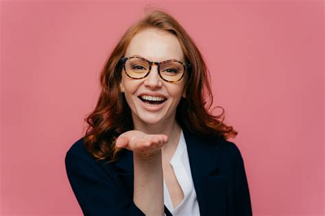 Photo Of Red Haired Beautiful Woman Stretches Palm Over Mouth Sends Air