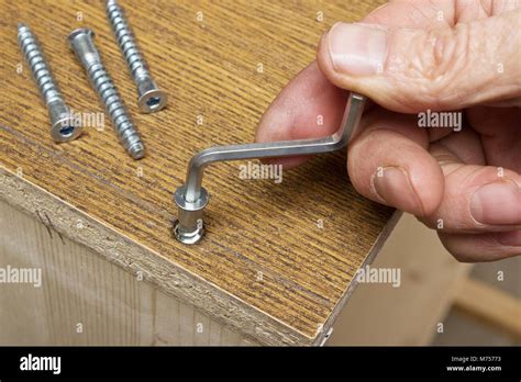 Tightening The Metal Screws By Hand When Assembling Furniture Stock