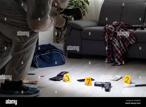 Detective Collecting Evidence In A Crime Scene Forensic Specialists