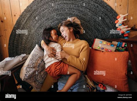Top View Of A Mother And Her Daughter Laughing Cheerfully At Home