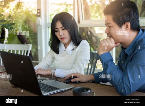 Young Asian Businessman And Businesswoman Talking About Their Work