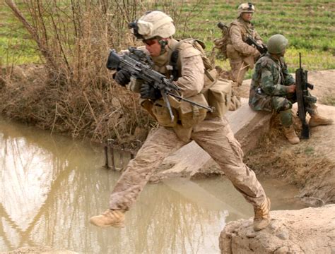 U S Marine Corps Lance Cpl Ryan Hogan Leaps Over An Irrigation Canal