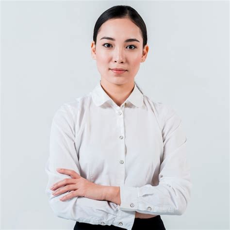 그녀의 팔을 가진 젊은 아시아 사업가의 초상화는 흰색 배경에 고립 된 카메라를 찾고 넘어 무료 사진