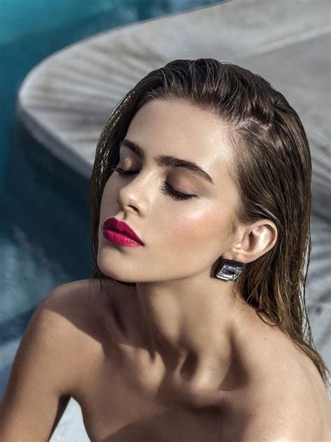 A Woman With Her Eyes Closed Sitting In Front Of A Swimming Pool