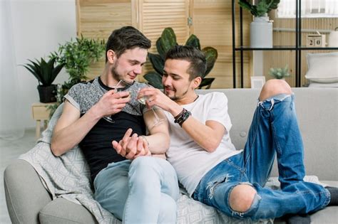 Premium Photo Young Gay Men Holding Hands On Sofa At Home Shy Gay