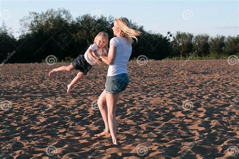 Mother And Daughter On The Beach Mother Spinning With Her Daughter In