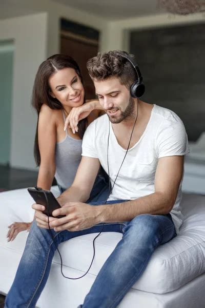 Man Listening Music Indoor By Headphones At Home With Grilfriend